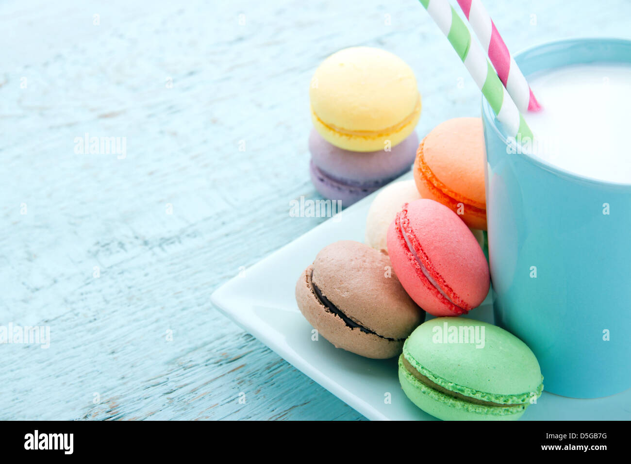Pastel color macaroons and milk with straw on blue vintage background ...