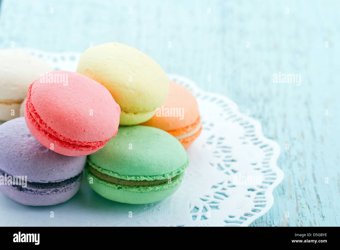 Pastel color macaroons on vintage blue wooden background Stock Photo ...