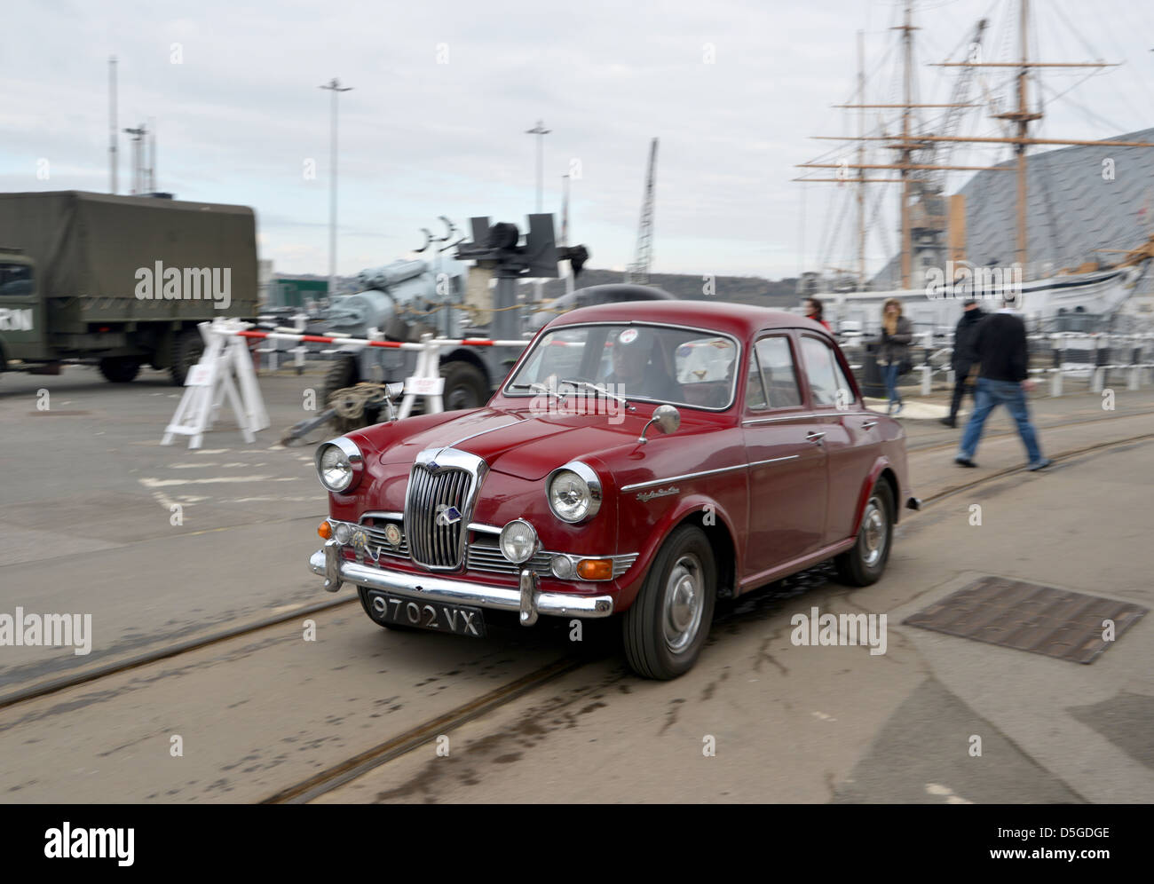 Riley Elf classic car drives through Chatham Historic Dockyard, tall ...