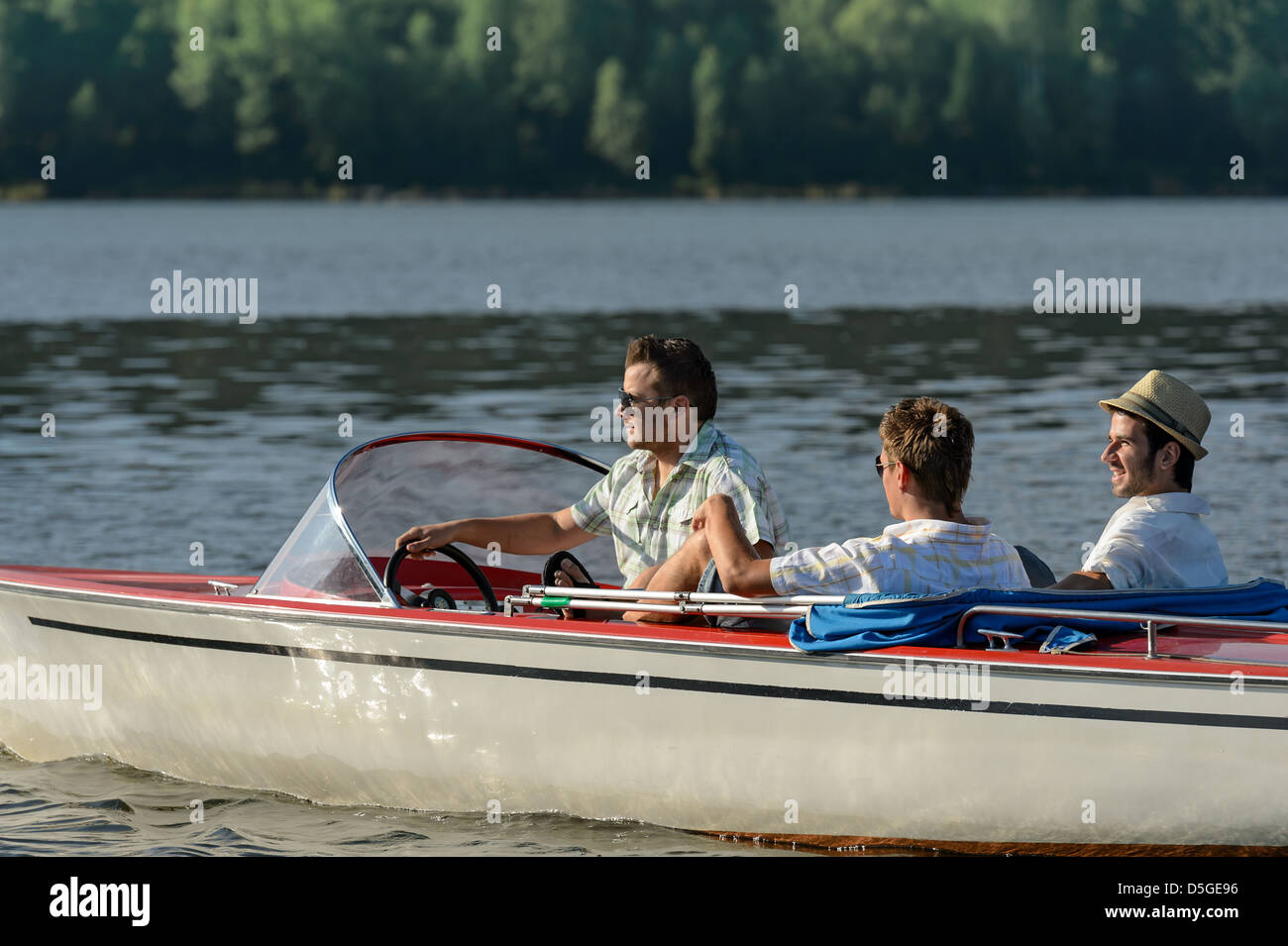 Young men driving speed boat enjoying sunshine Stock Photo - Alamy
