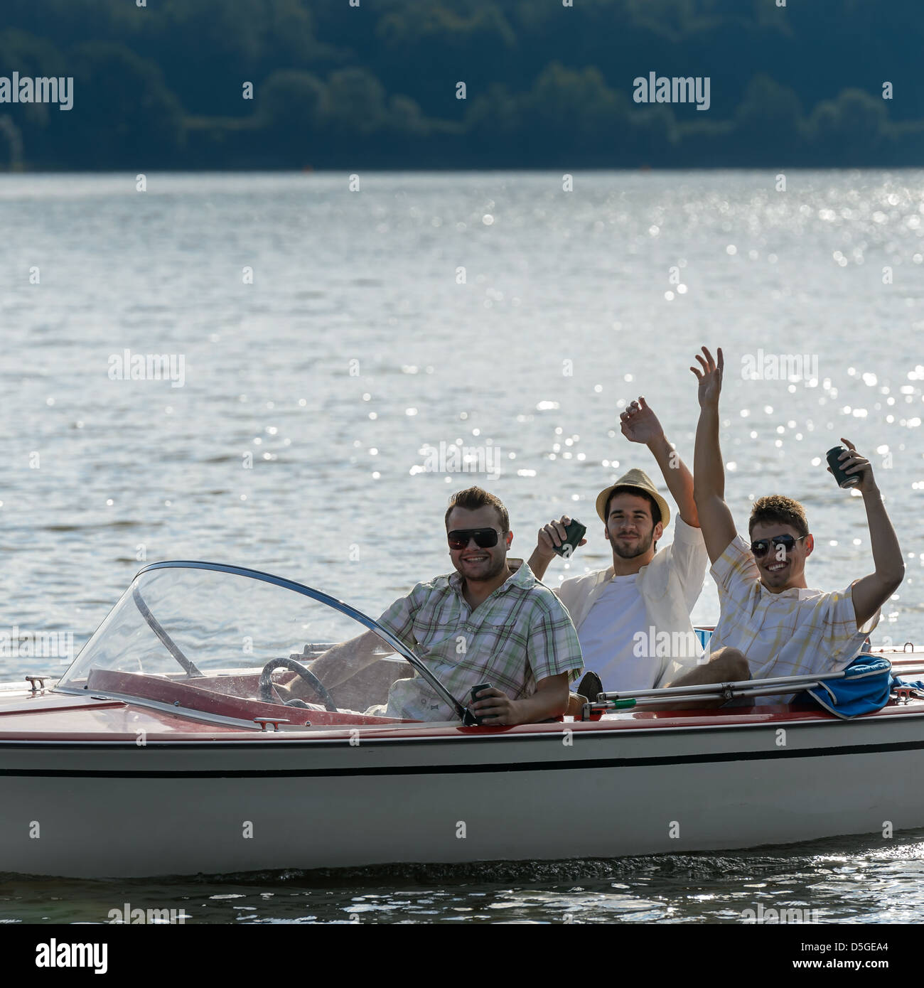 Cheerful young men party drinking beer on speed boat Stock Photo - Alamy