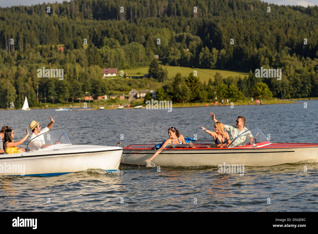 Young friends having fun in motorboats waving and splashing water Stock ...