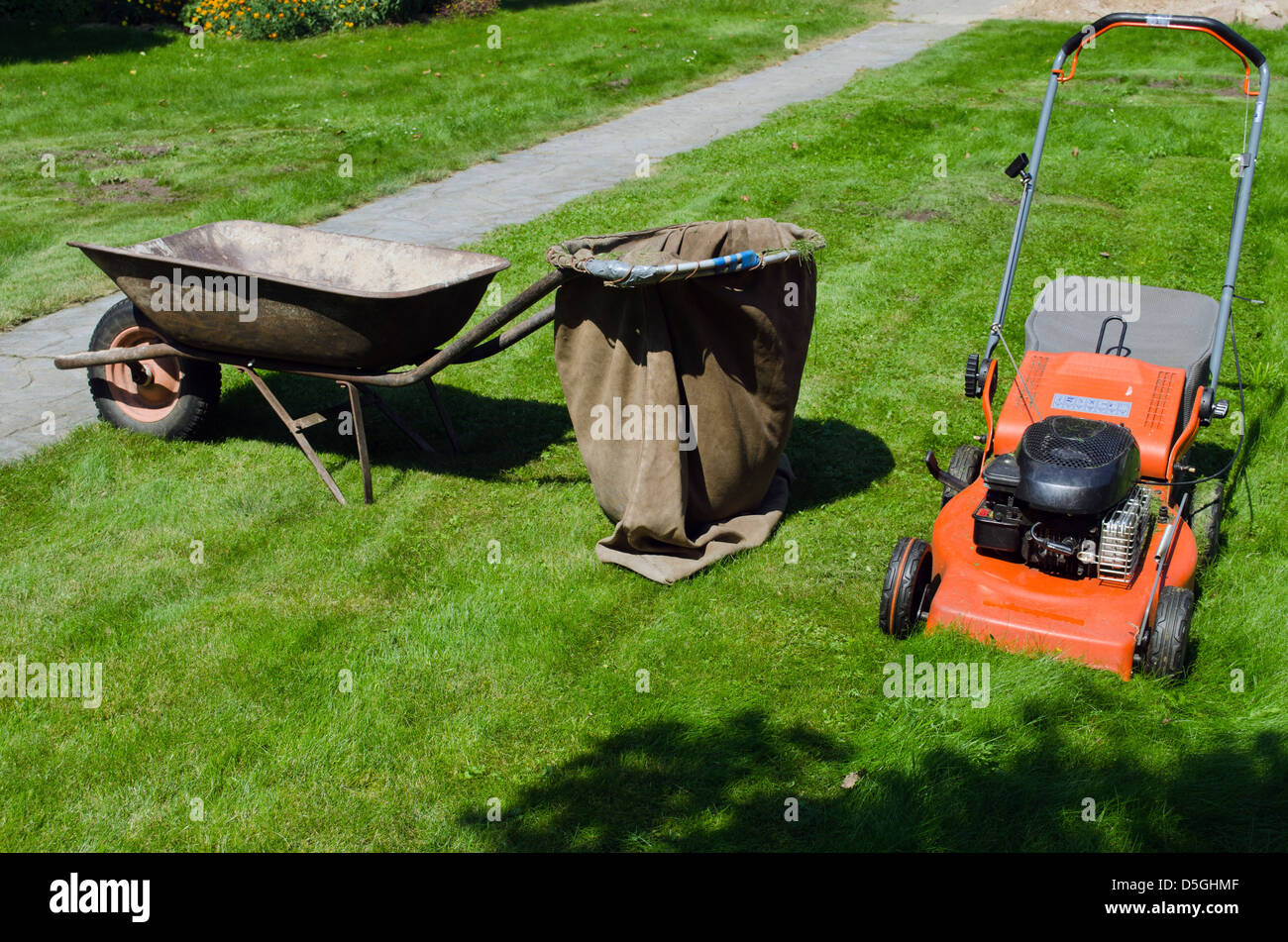 ready for operation mower and wheelbarrow to throw the grass Stock ...