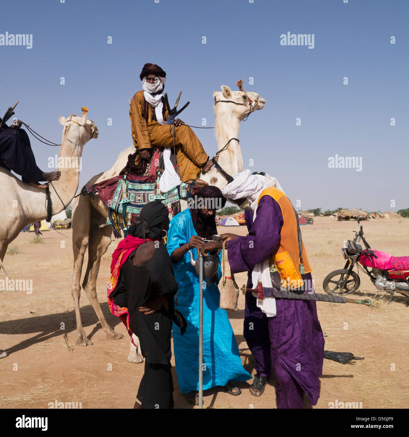 Wodaabe nomads are getting water from a tap in the desert in northern ...