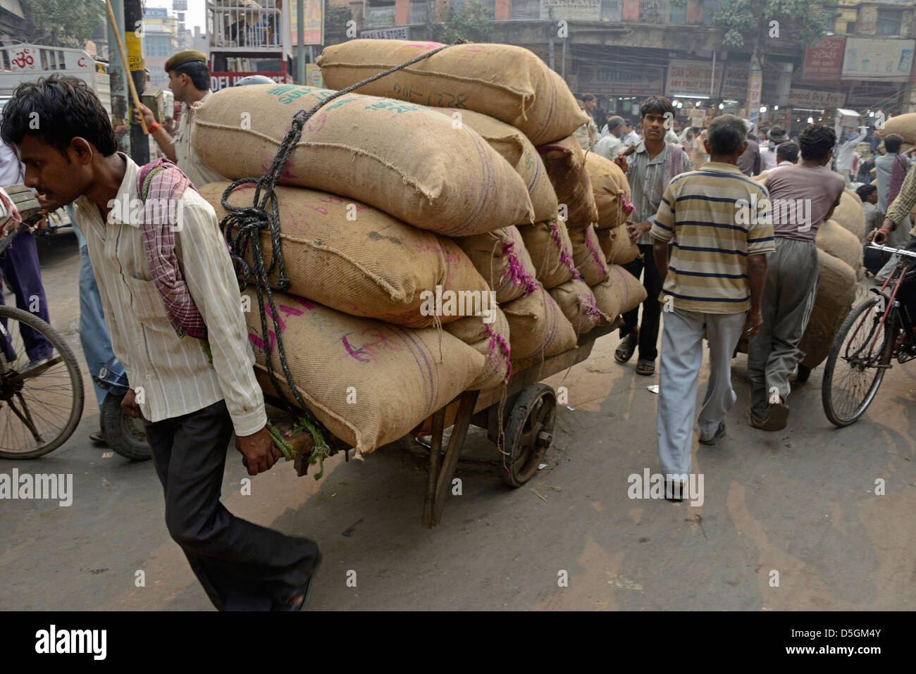 A wheelbarrow worker carrying his load of rice to a shop in Khari Baoli ...