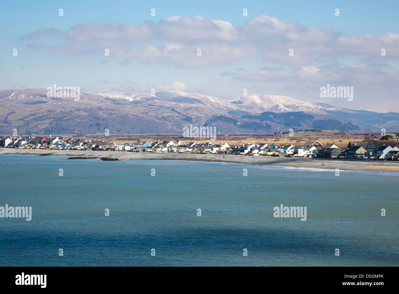A blue green sea with the exposed coastal village of Borth, and snow ...