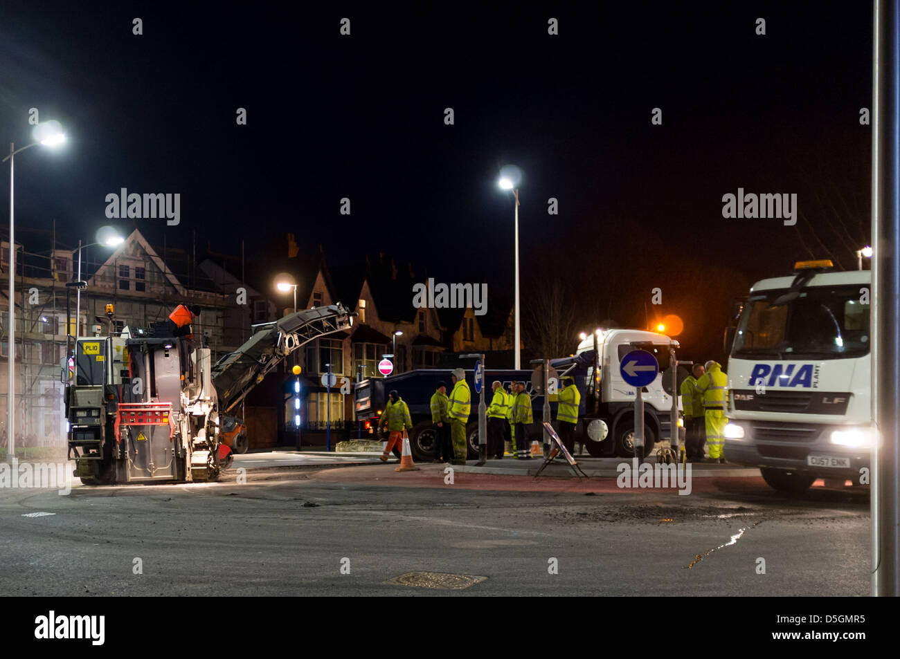 A gang of men at work, relaying road surface, night time Roadworks ...