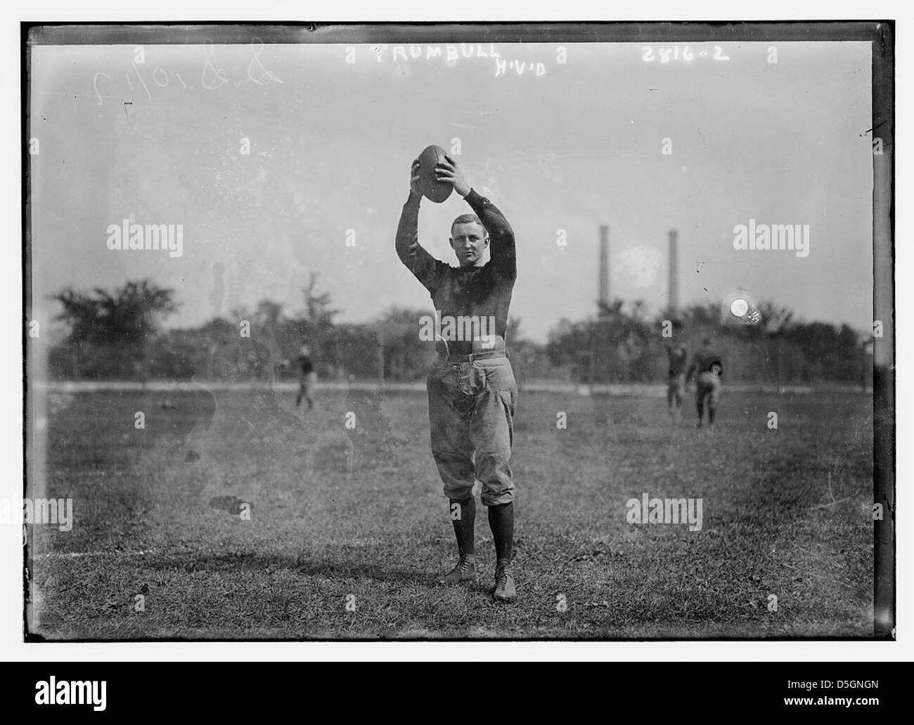 A photograph of a Harvard football team player posed during practice ...