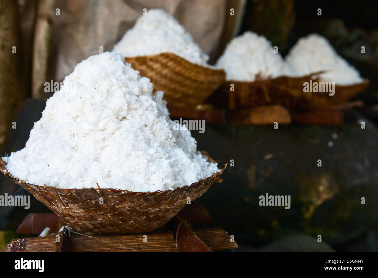 Basket with fresh extracted natural sea salt on salt production farm in ...