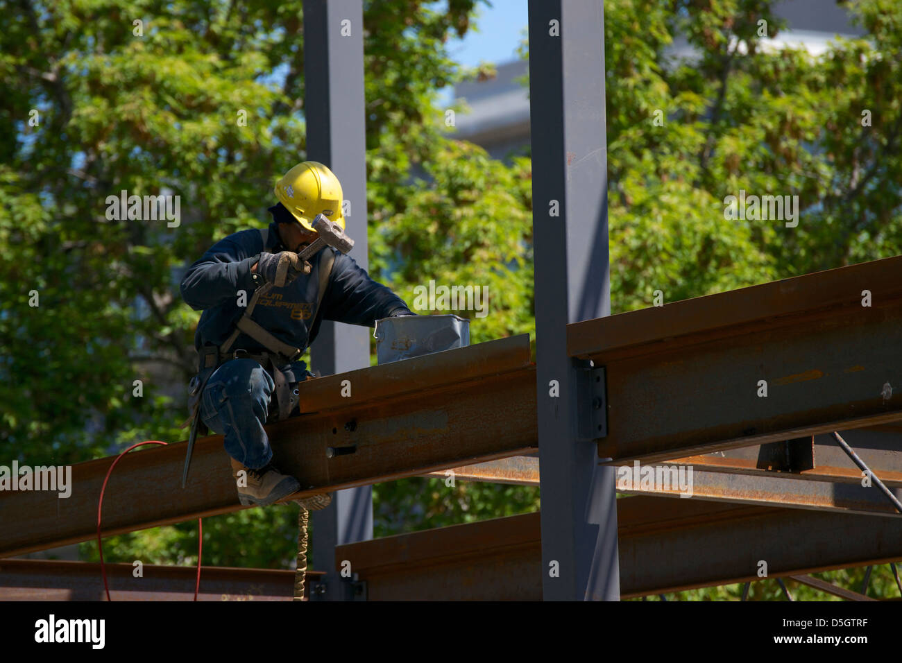 Ironworker connecting steel beams during construction of a building ...