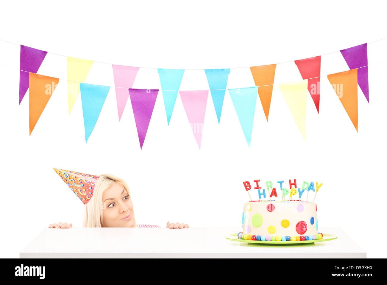 Birthday girl with a party hat looking at a birthday cake isolated on ...
