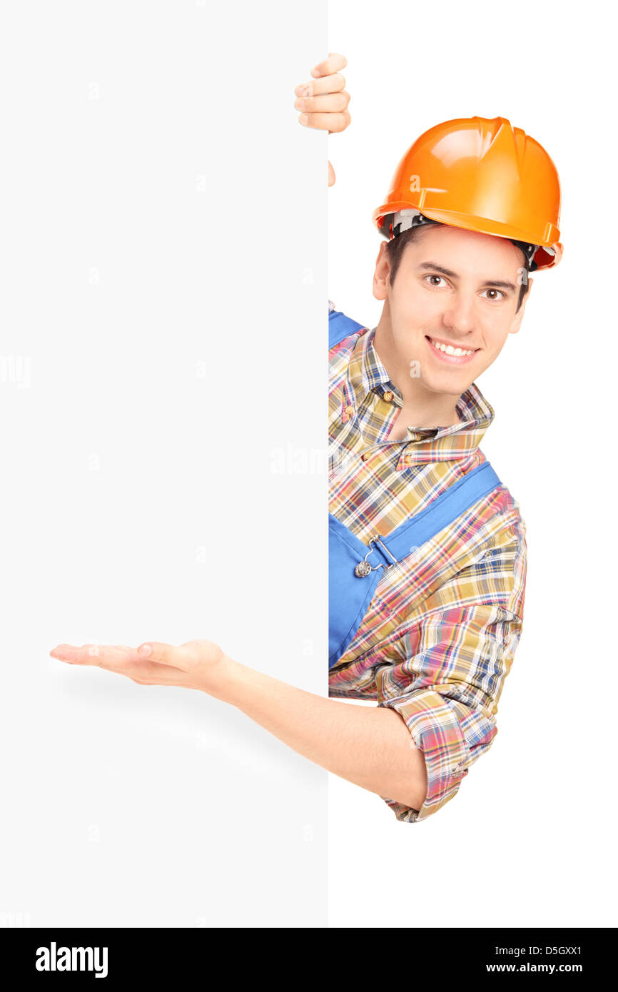 Young construction worker with helmet posing and gesturing on a panel ...