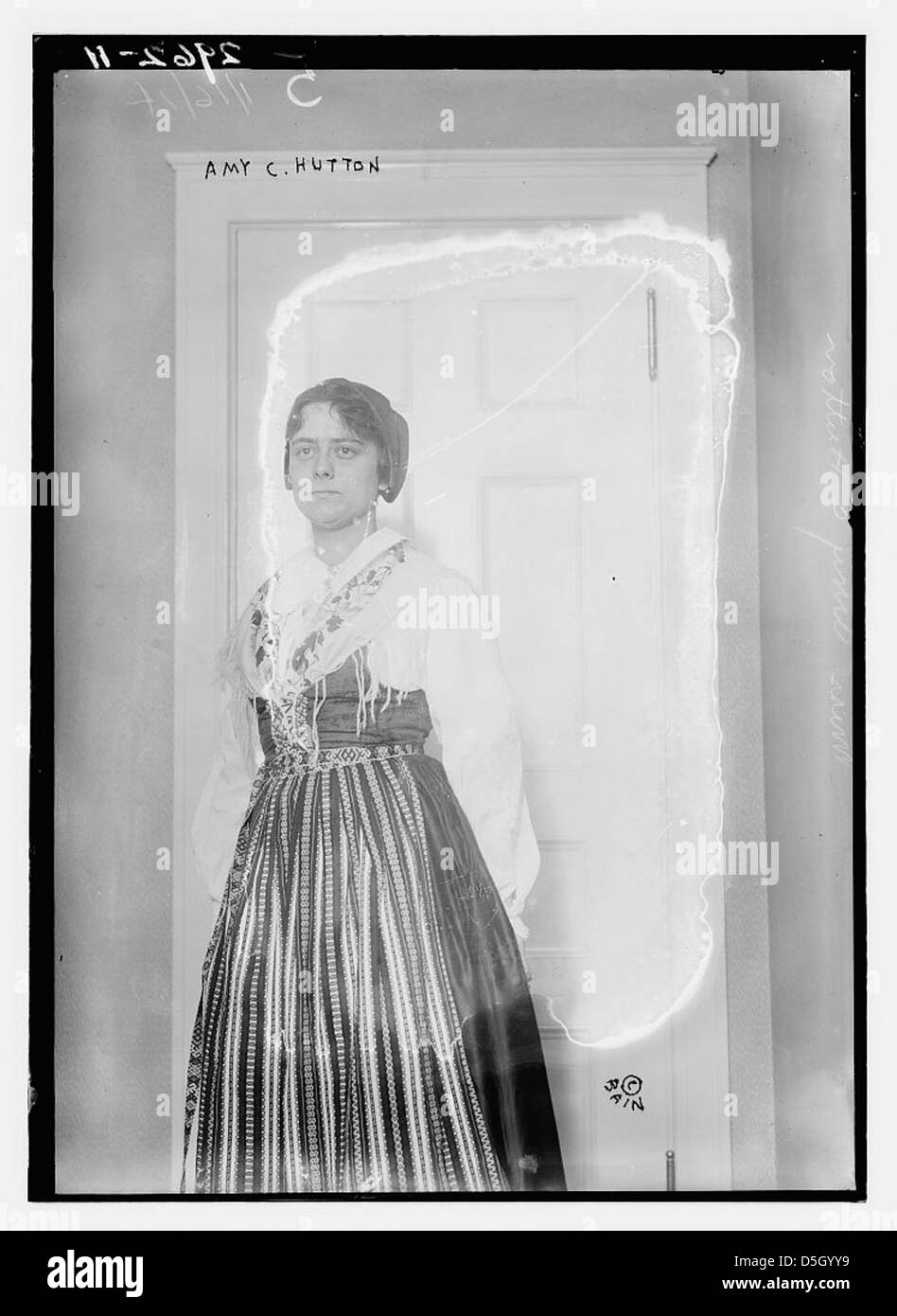 Amy C. Hutton is seen standing in a striped dress, captured in a ...