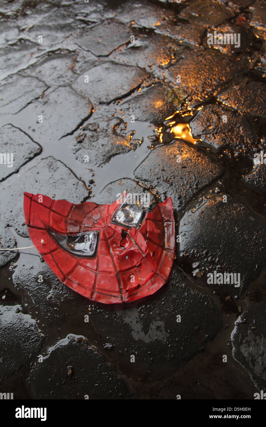 broken spiderman plastic mask on wet road in city town Stock Photo - Alamy