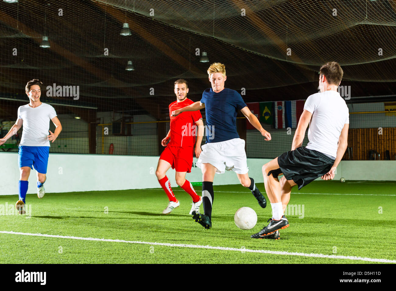 Men team playing football or soccer indoor and trying to score a goal ...