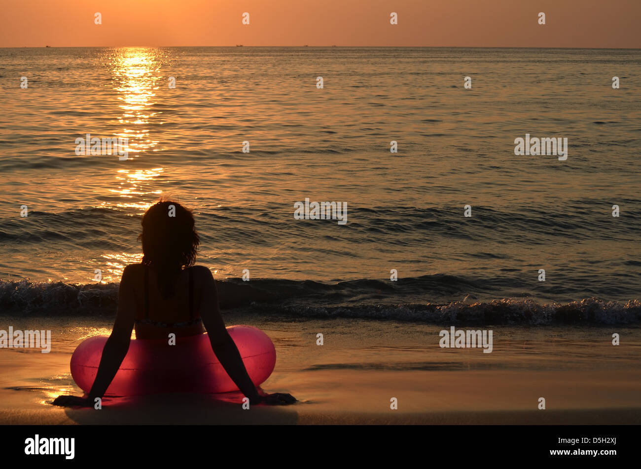 Women with pink ring at the ocean Stock Photo - Alamy