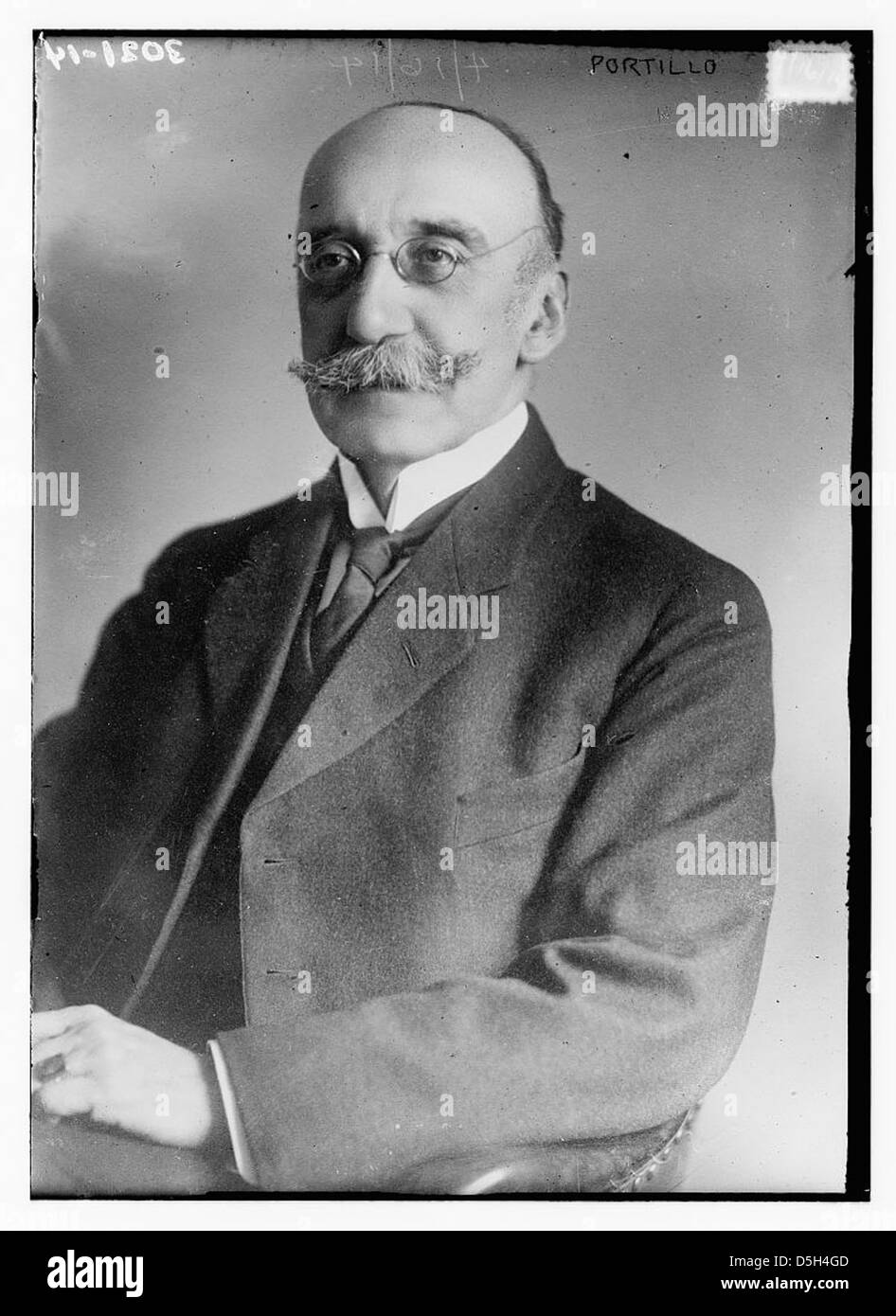 A man with a notable mustache is photographed in a portrait, likely ...
