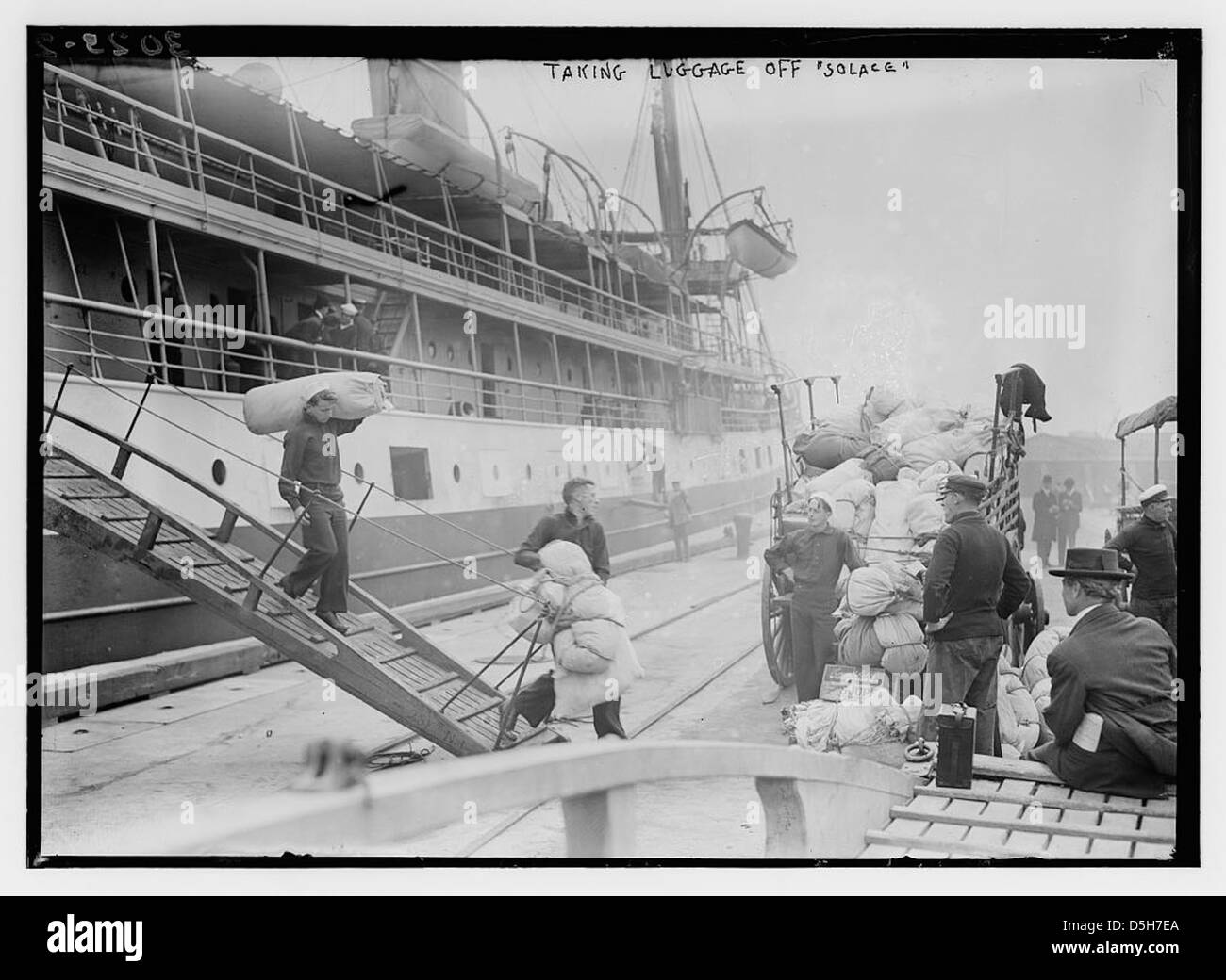 This photograph depicts the unloading of luggage from the USS Solace ...