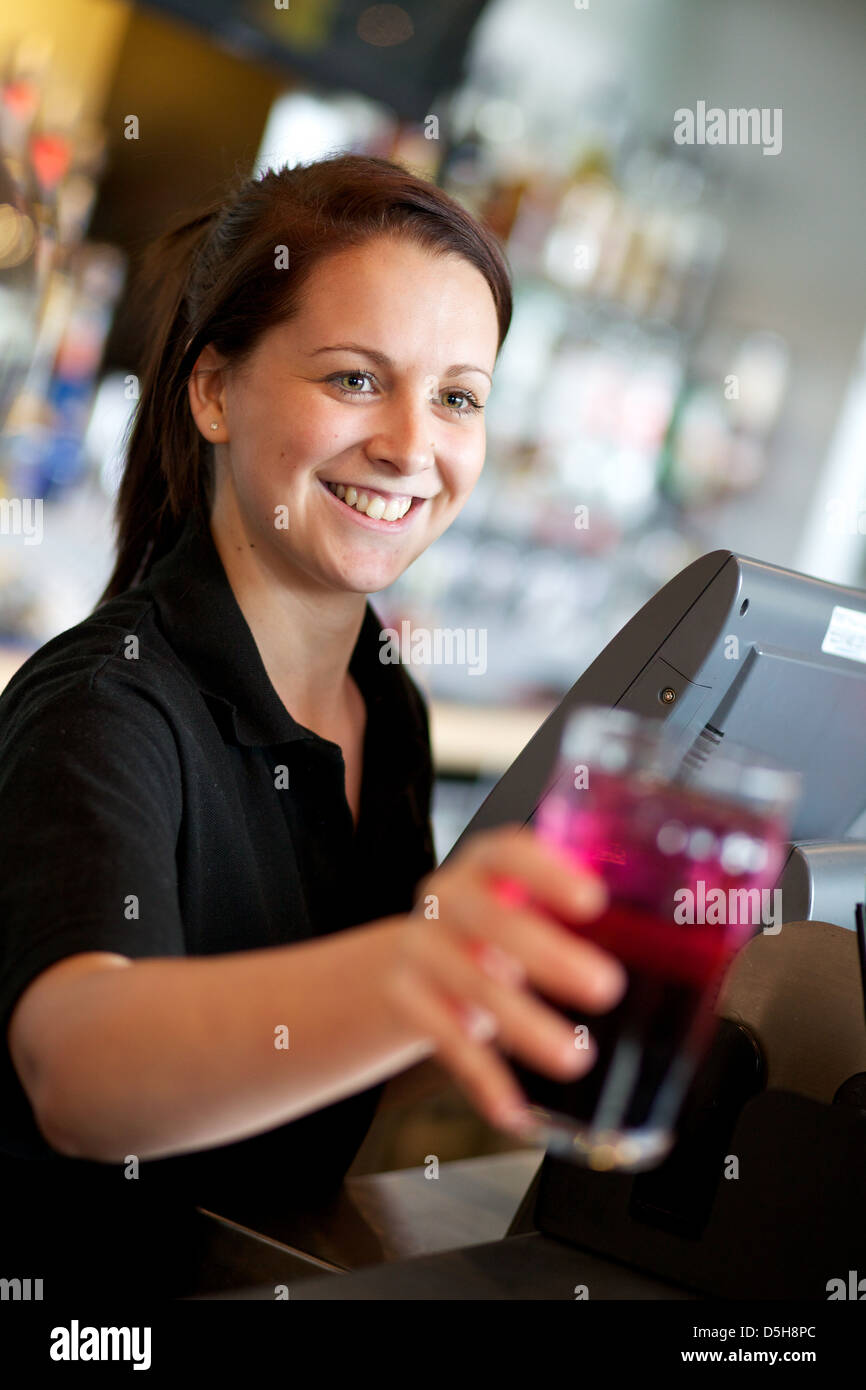 young woman serving behind a bar Stock Photo - Alamy