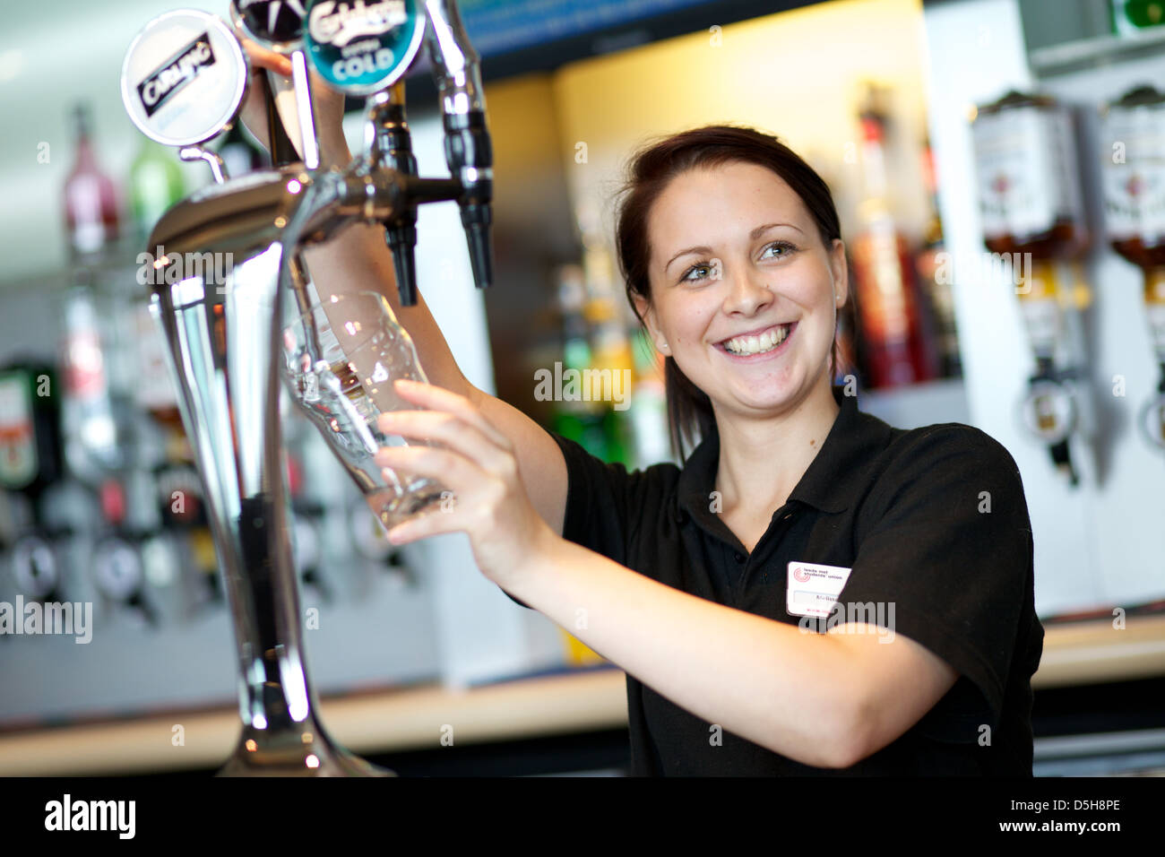 young woman serving behind a bar Stock Photo - Alamy