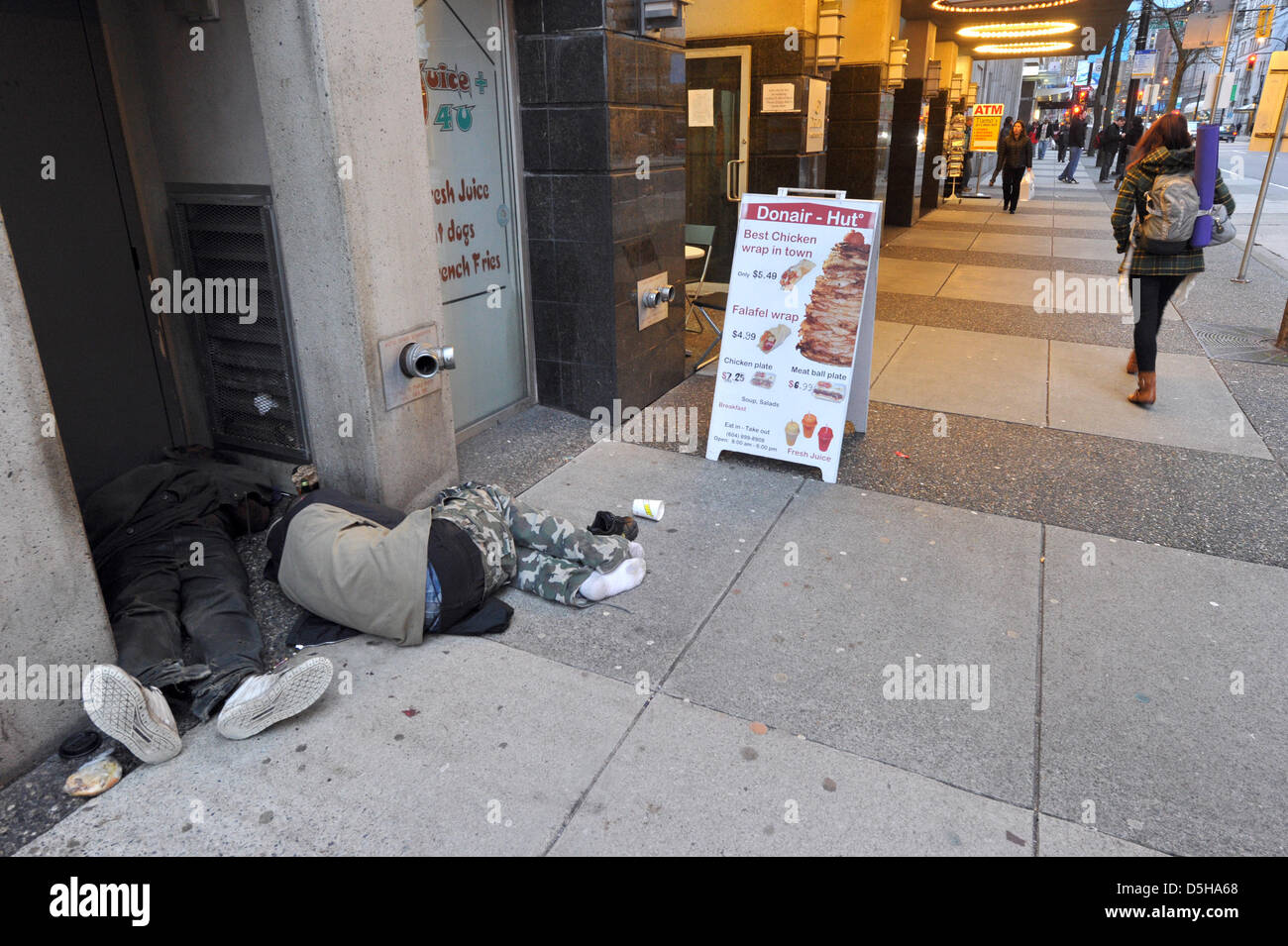 Two homeless people sleep in a house entrance in Vancouver, Canada, 03 ...