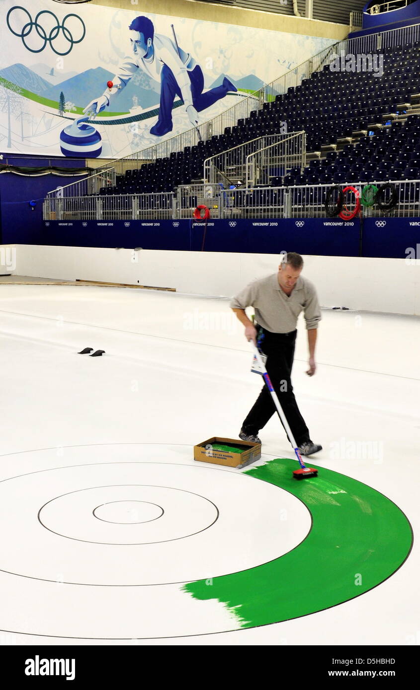 A worker paints the twelve foot on the sheet for the Curling ...