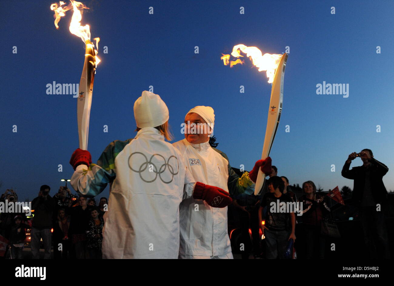 Marsha Taylor (L) and her fellow torchbearer Thomas Bach, president of ...
