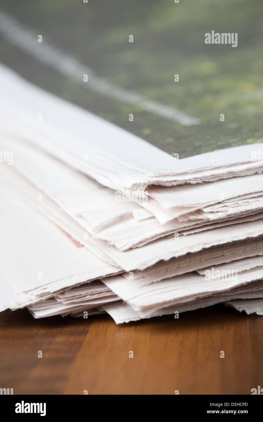 Folded newspapers on brown wooden table Stock Photo - Alamy