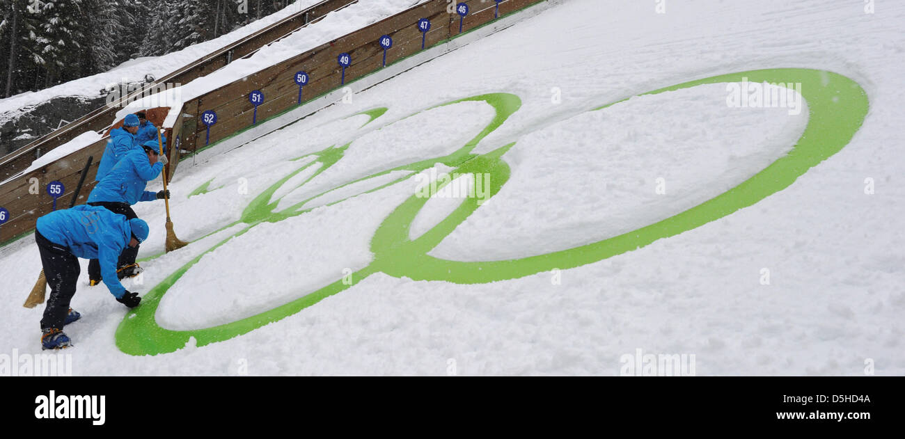 Workers shovel snow out of the inrun during the Nordic Combined ski ...