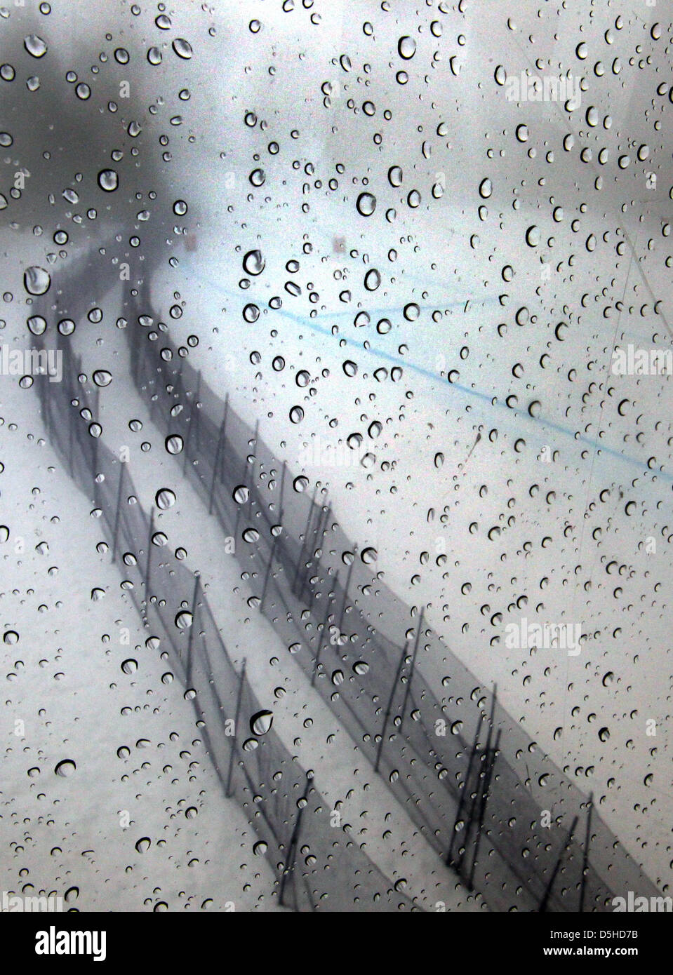 General view of the slope through the rain-covered window of the car of ...