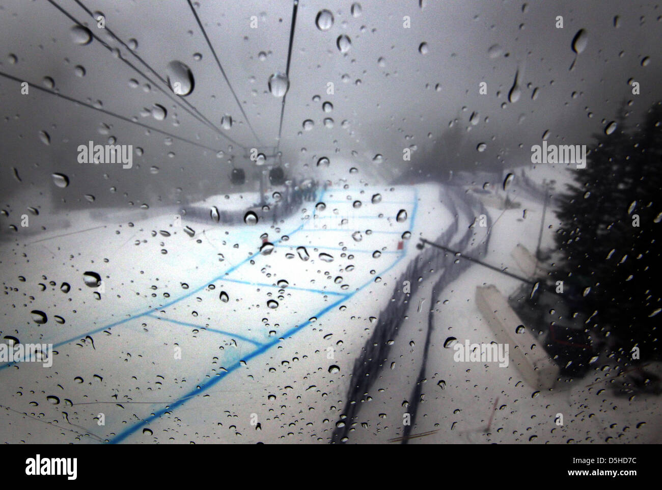 General view of the slope through the rain-covered window of the car of ...
