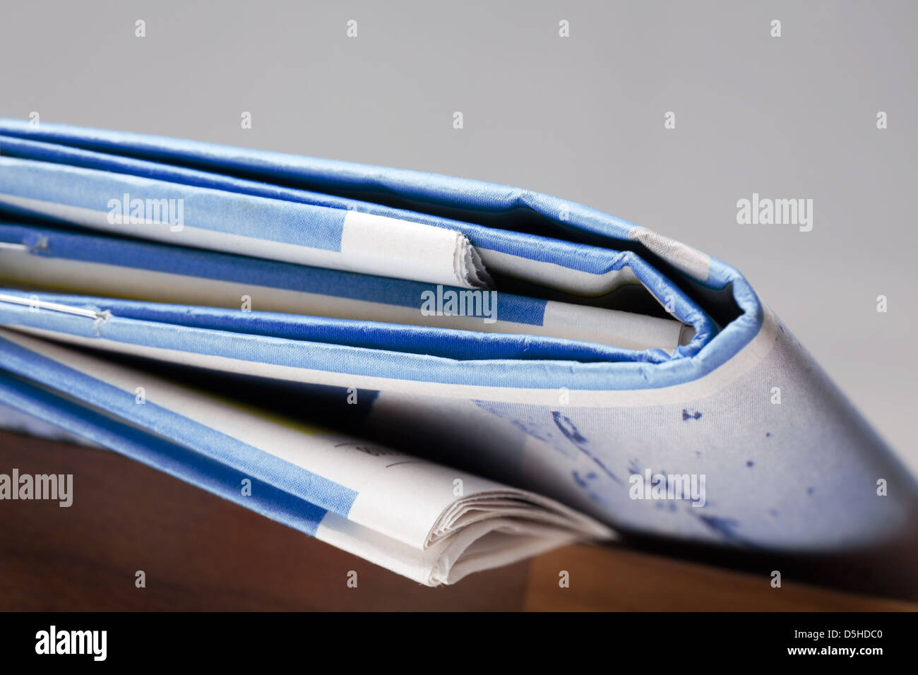 Folded newspapers on brown wooden table Stock Photo - Alamy