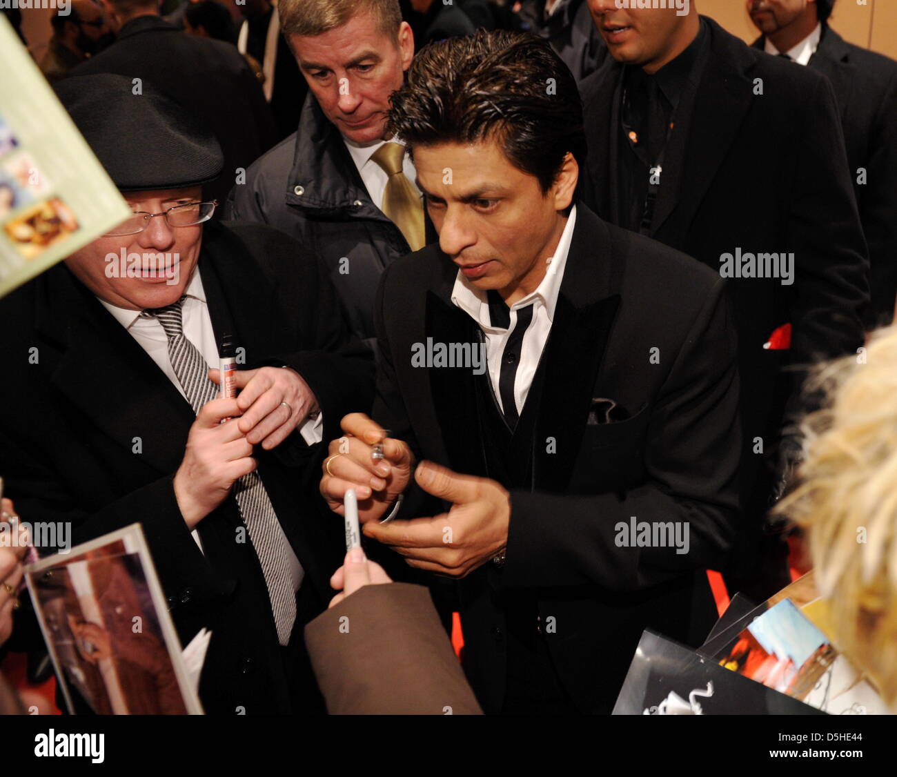 Indian actor Shah Rukh Khan signs autographes as he arrives for the ...