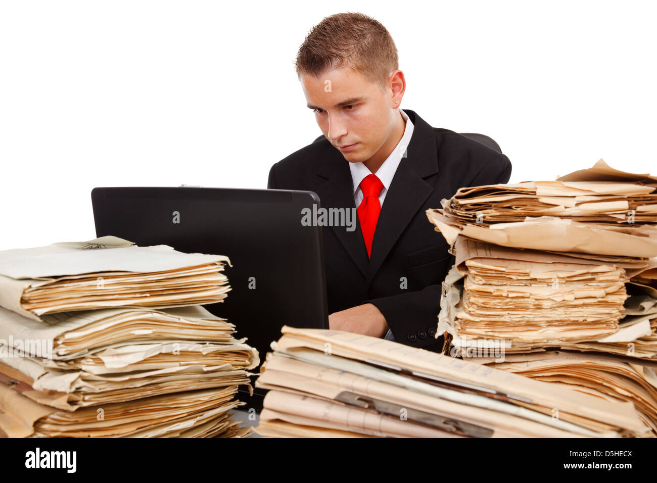 Man working on laptop computer, surrounded with lots of paperwork Stock ...