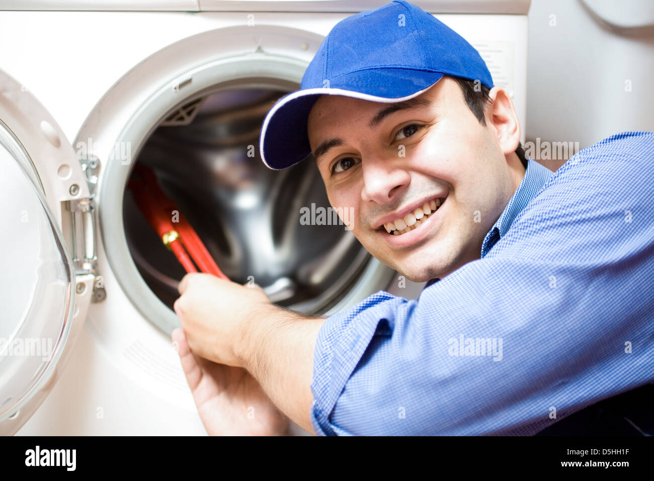 Portrait of a technician repairing a washing machine Stock Photo - Alamy