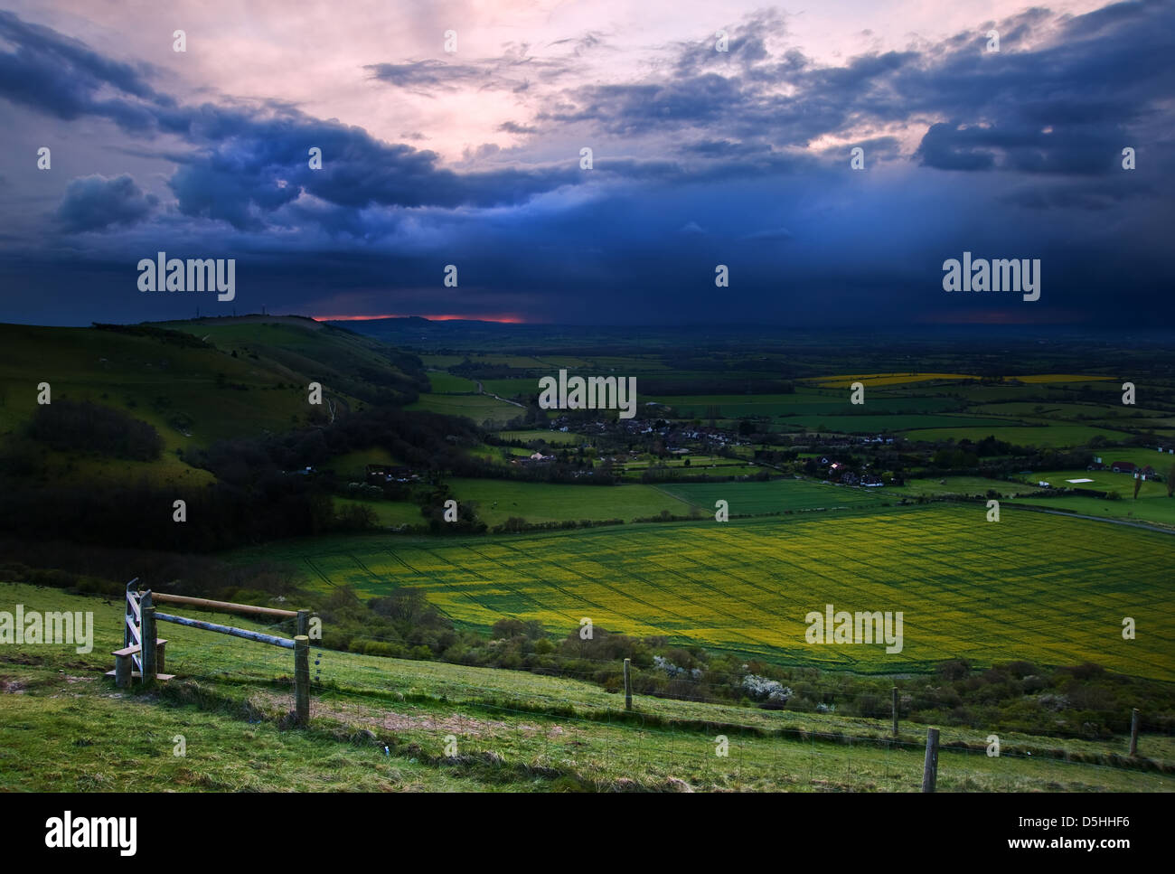 Dark moody skies form over bright fresh Spring countryside landscape ...