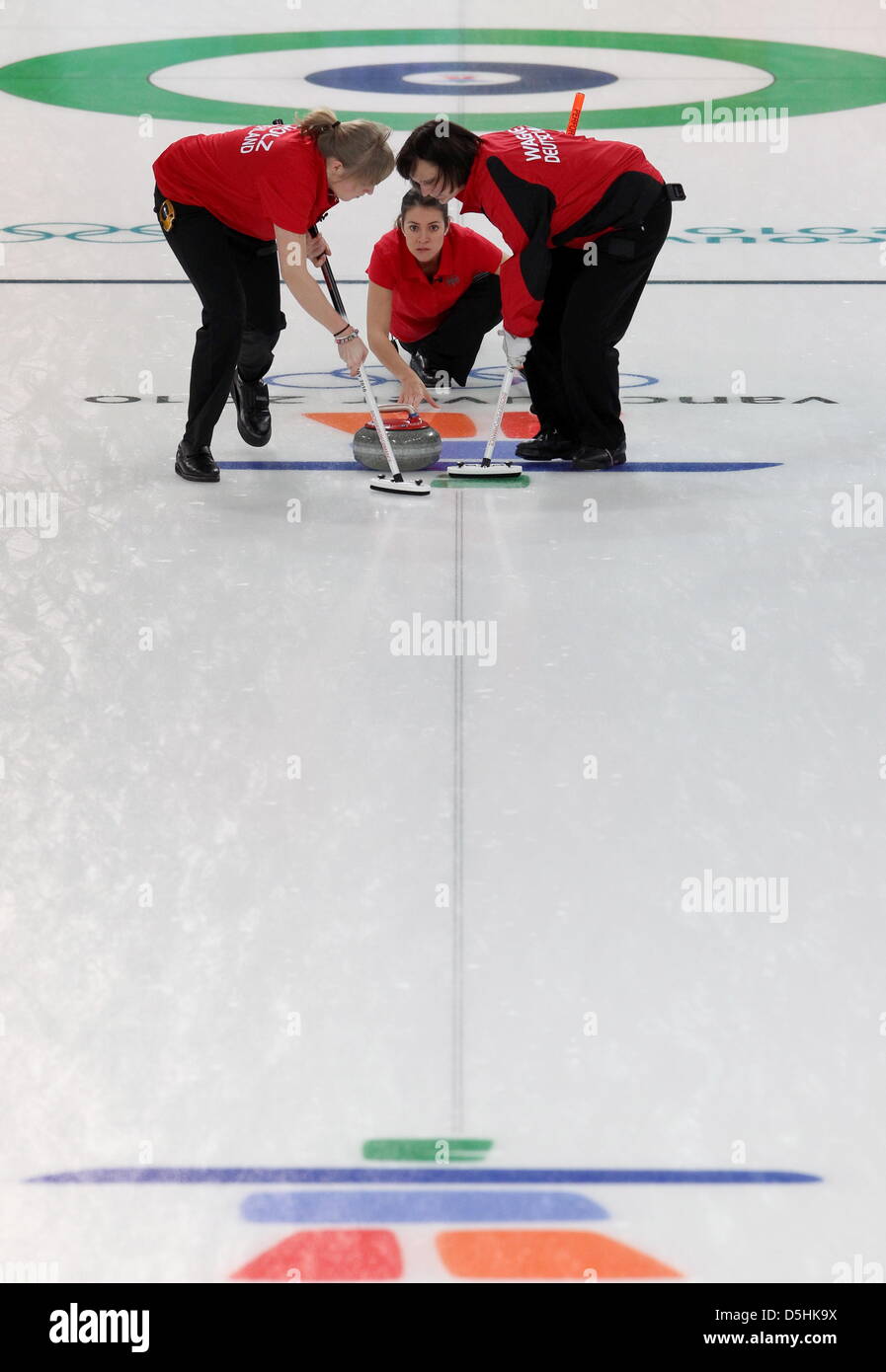 Germany's Melanie Robillard (C) releases her stone as team-mates ...