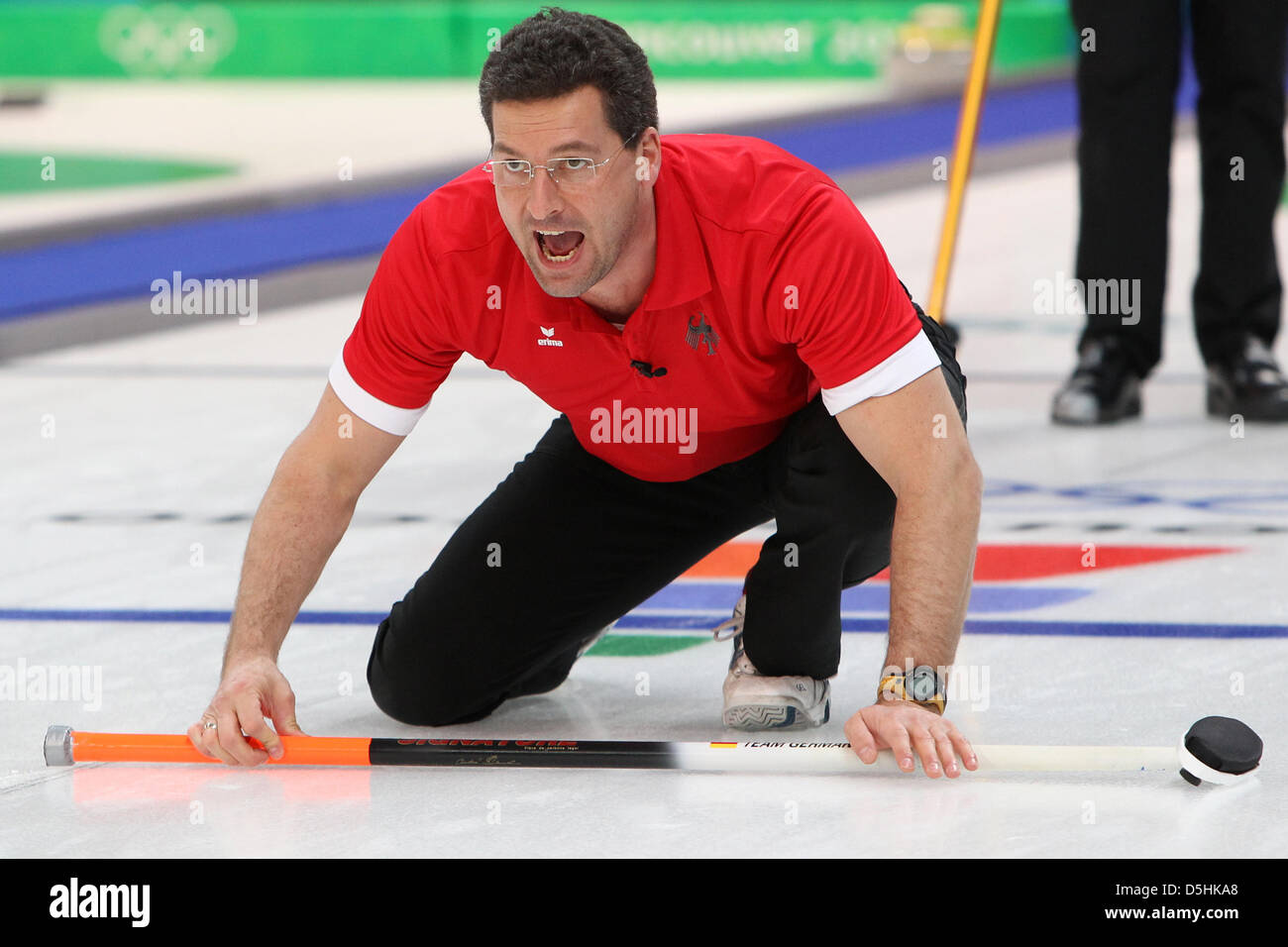 Skip Andy Kapp of Germany gives instructions to guide the stone during ...