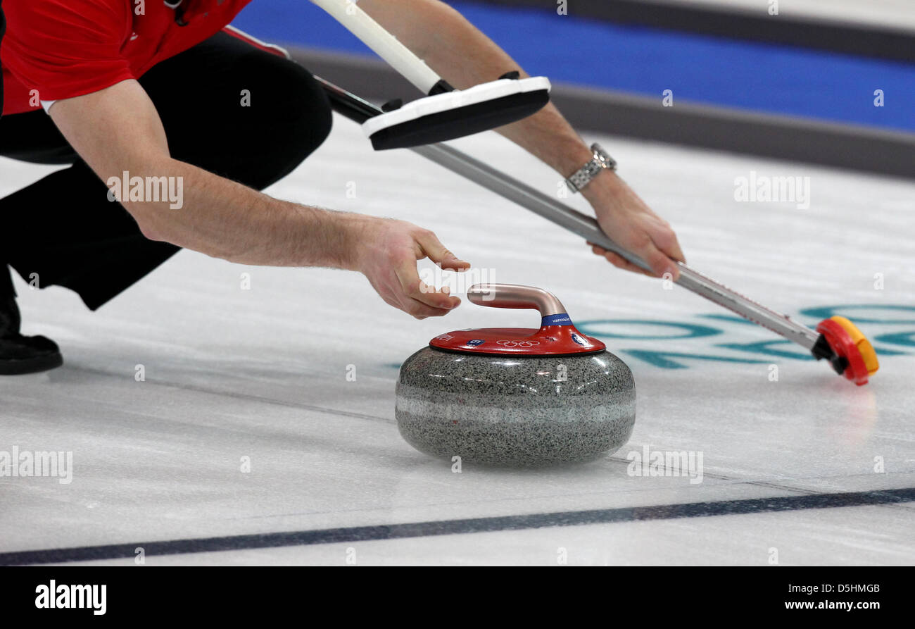 A player of team Germany plays his stone during their curling men's ...