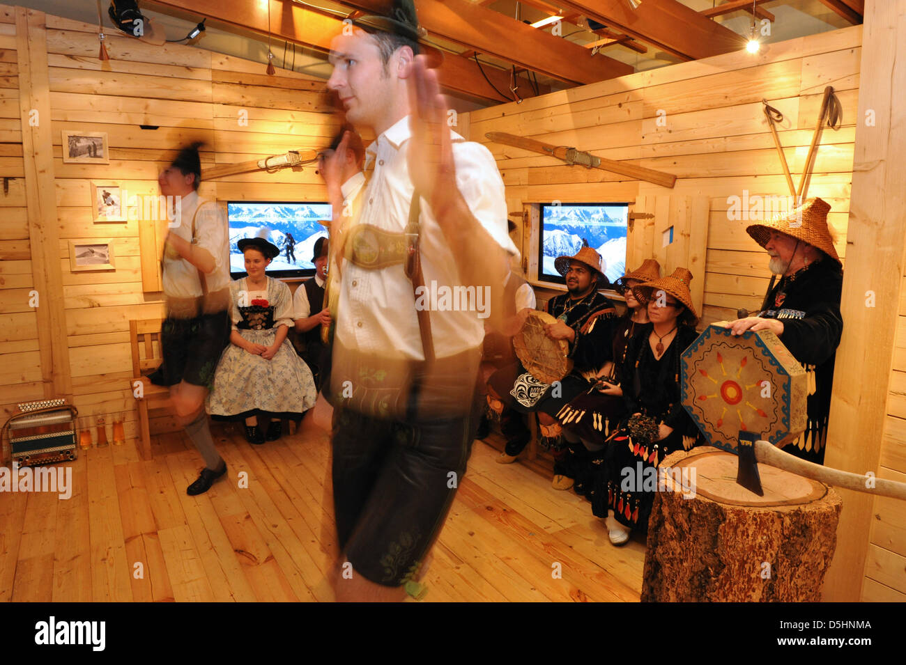 A Canadian First Nations Dance Group (R) watches Bavarian folk dancers ...