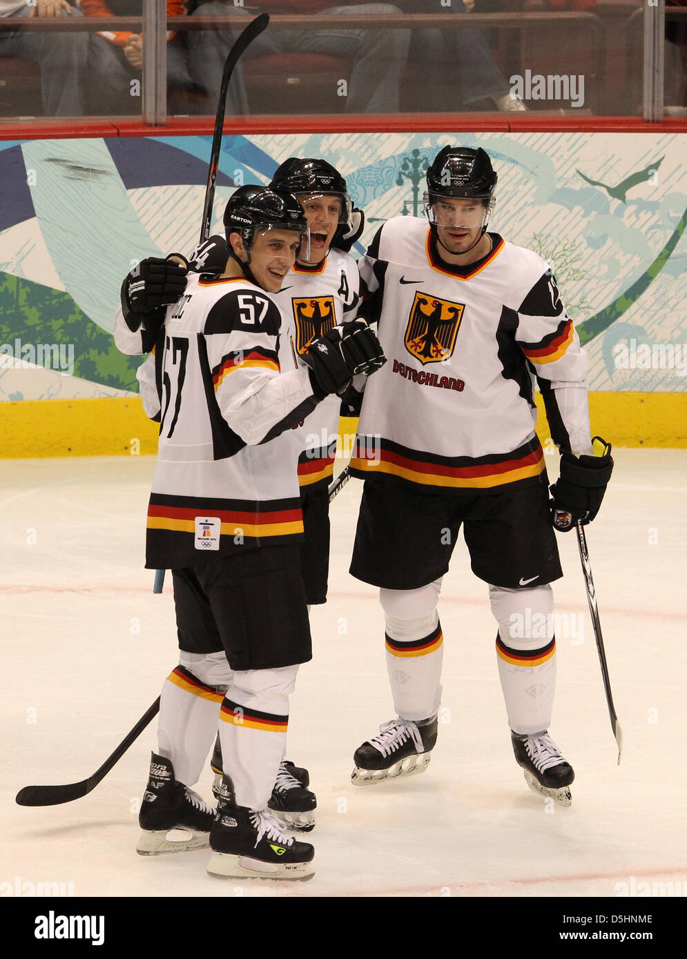 Marcel Goc (L), Dennis Seidenberg (C) and Jochen Hecht of Germany cheer ...