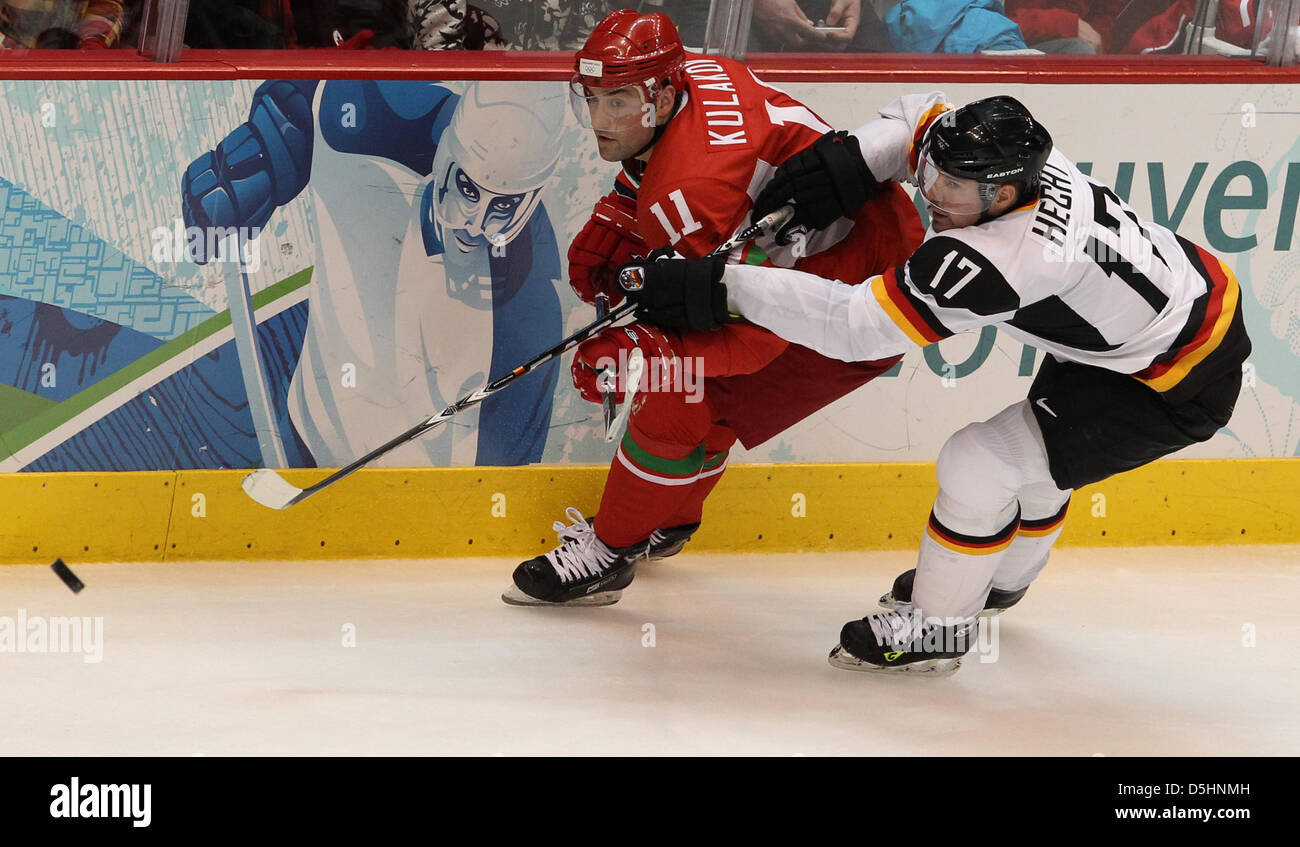 Jochen Hecht (R) of Germany fights for the puck with Aleksandr Kulakov ...