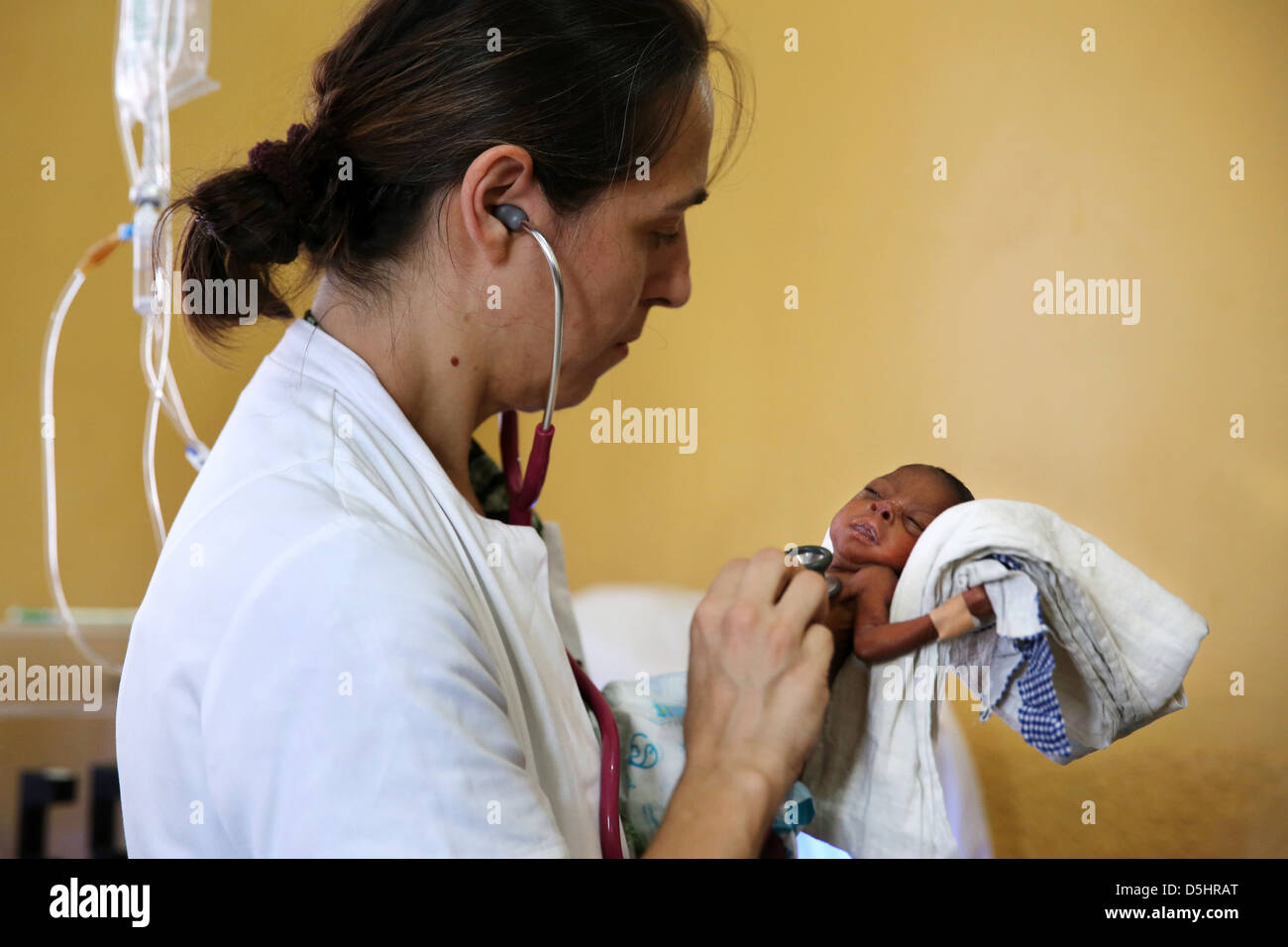 female german doctor examining newborn african baby. Hospital in ...