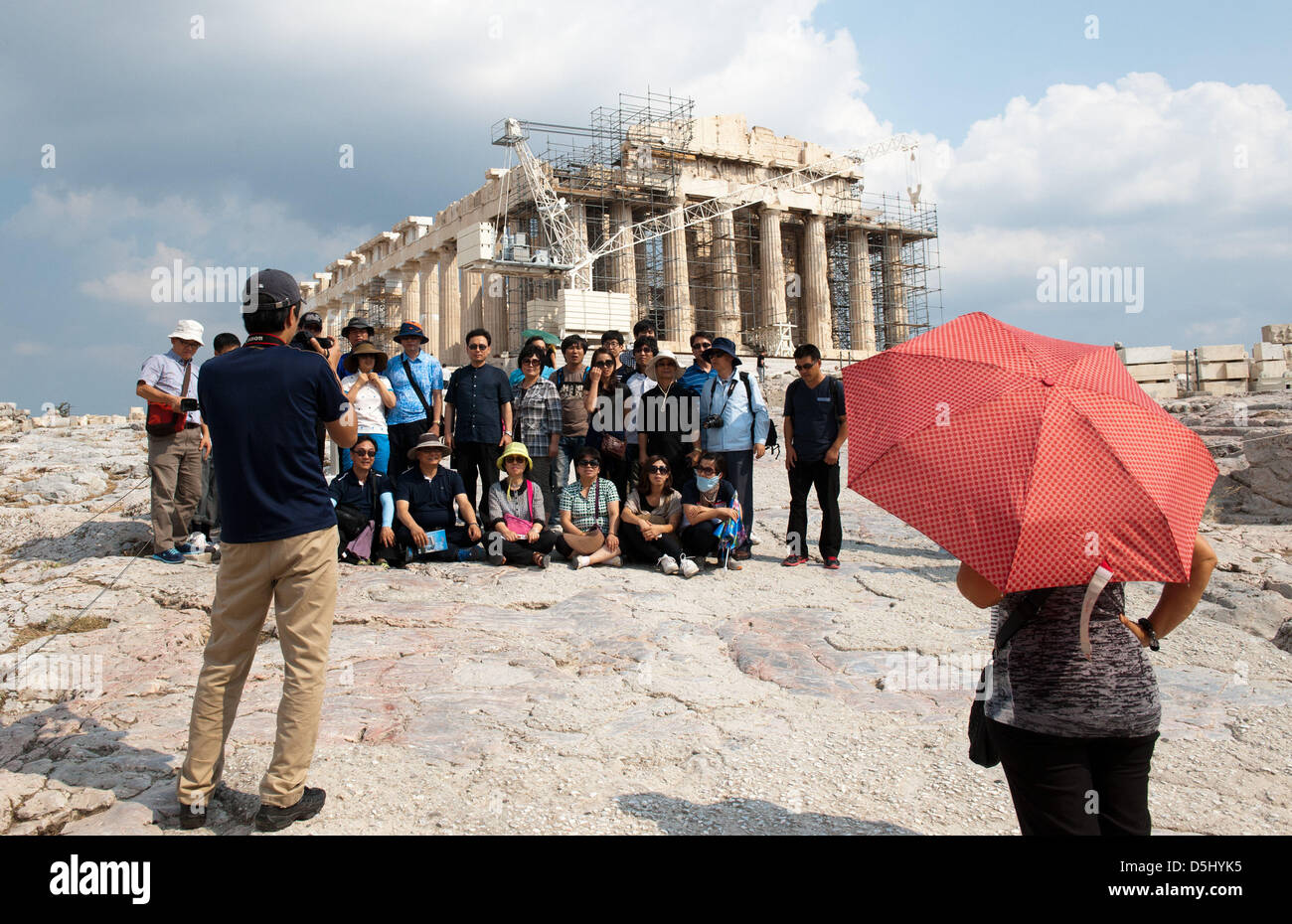A Asian tourist group is photographed in front of the Acropolis in ...