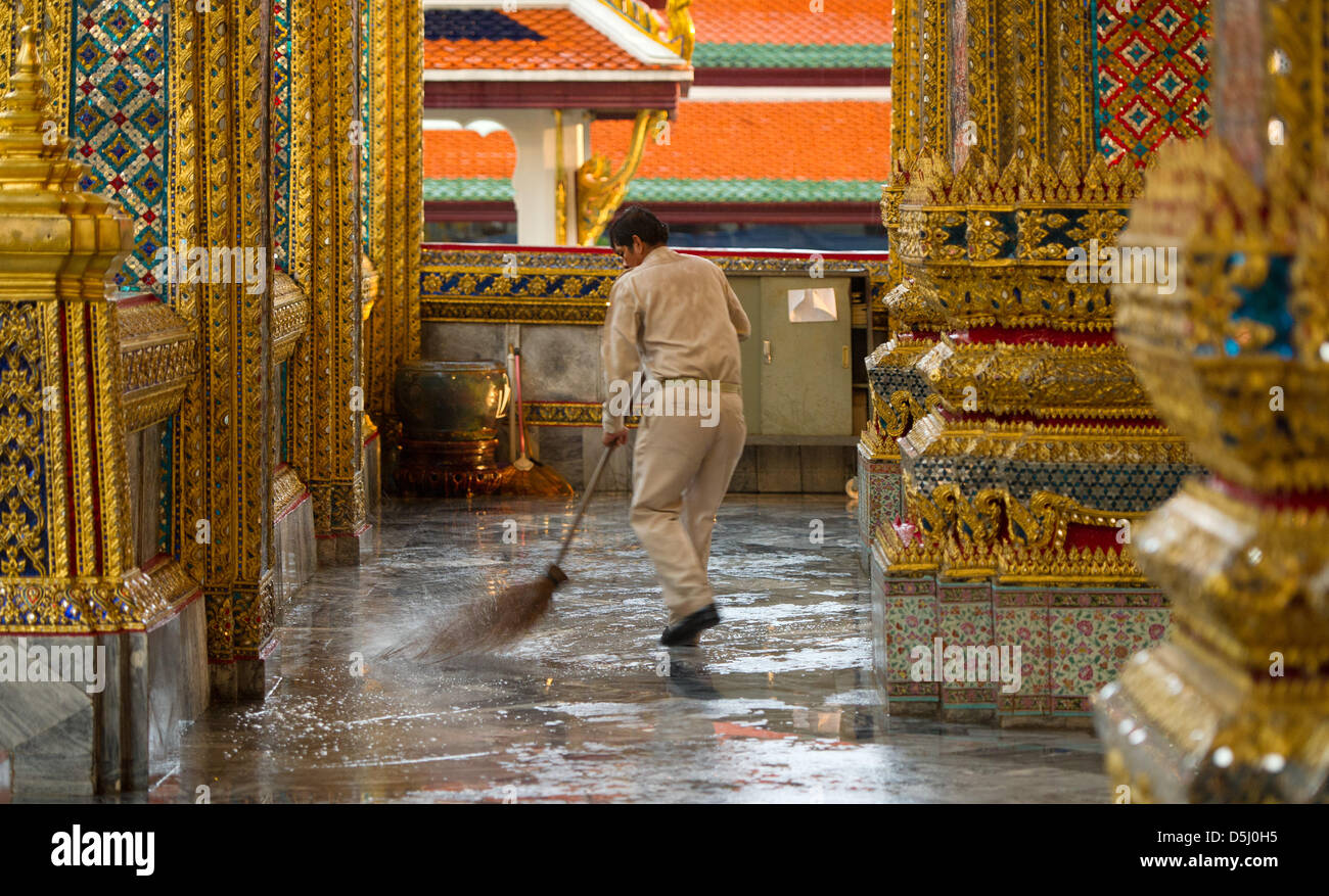 An emplyoee sweeps water from the Royal Palace in Bangkok, Thailand, 20 ...