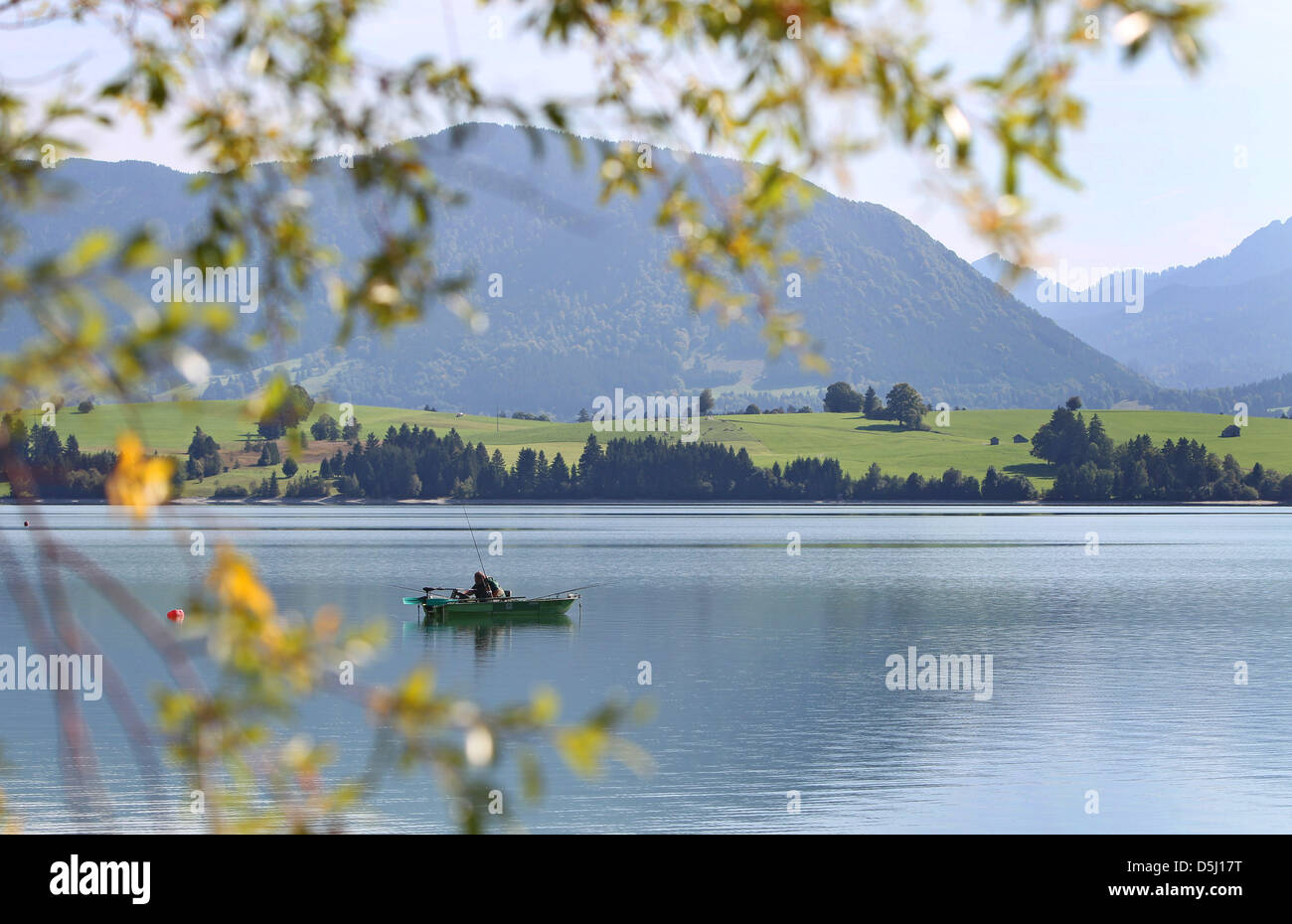 A fisher drifts on Forggensee lake near Waltenhofen, Germany, 21 ...