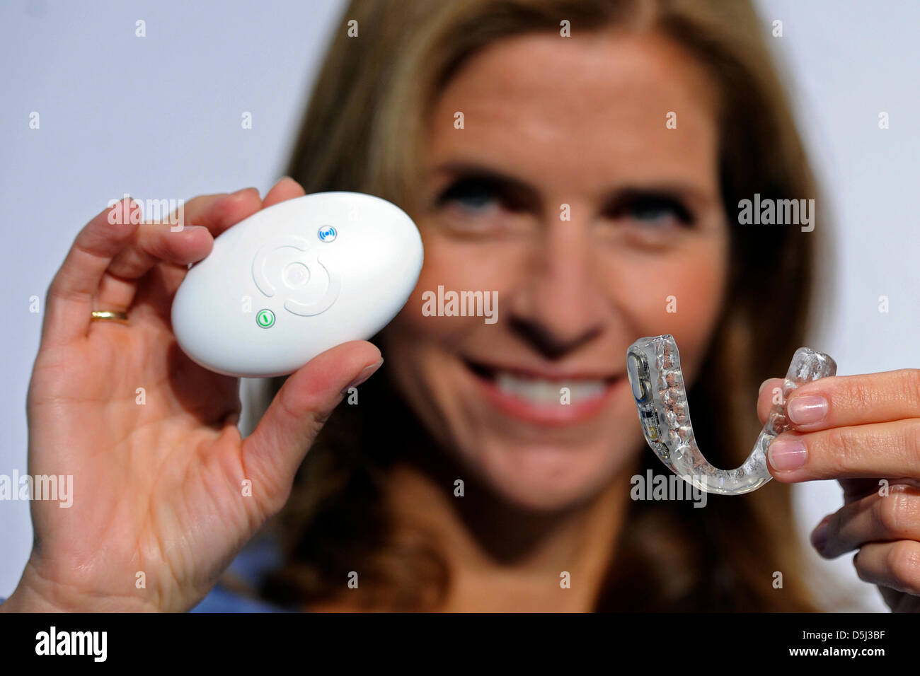 A model holds a teeth guard with built in sensor from the Technical ...