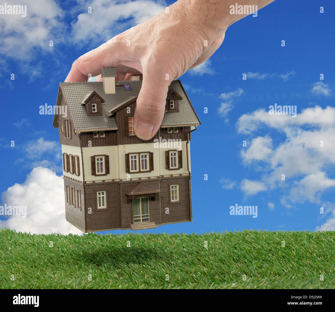 handplacing new house at grass property Stock Photo - Alamy