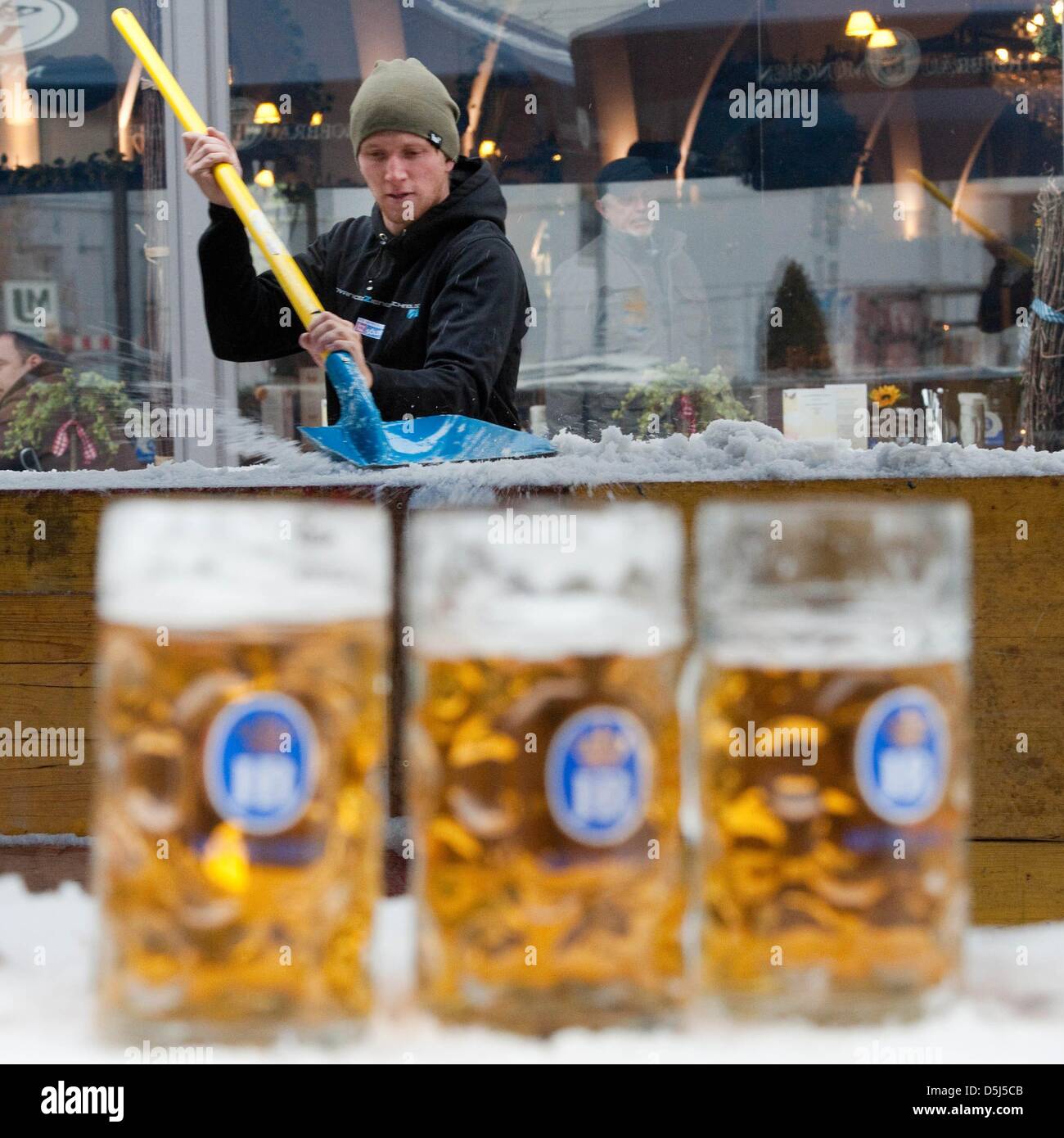 Three mugs of beer sit in front of delivered snow in front of Hofbraeu ...