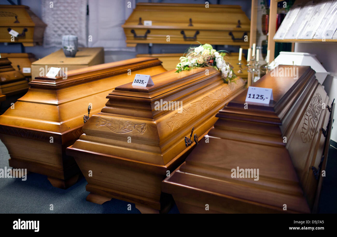 Various wooden coffins in different price classes sit in a display room ...